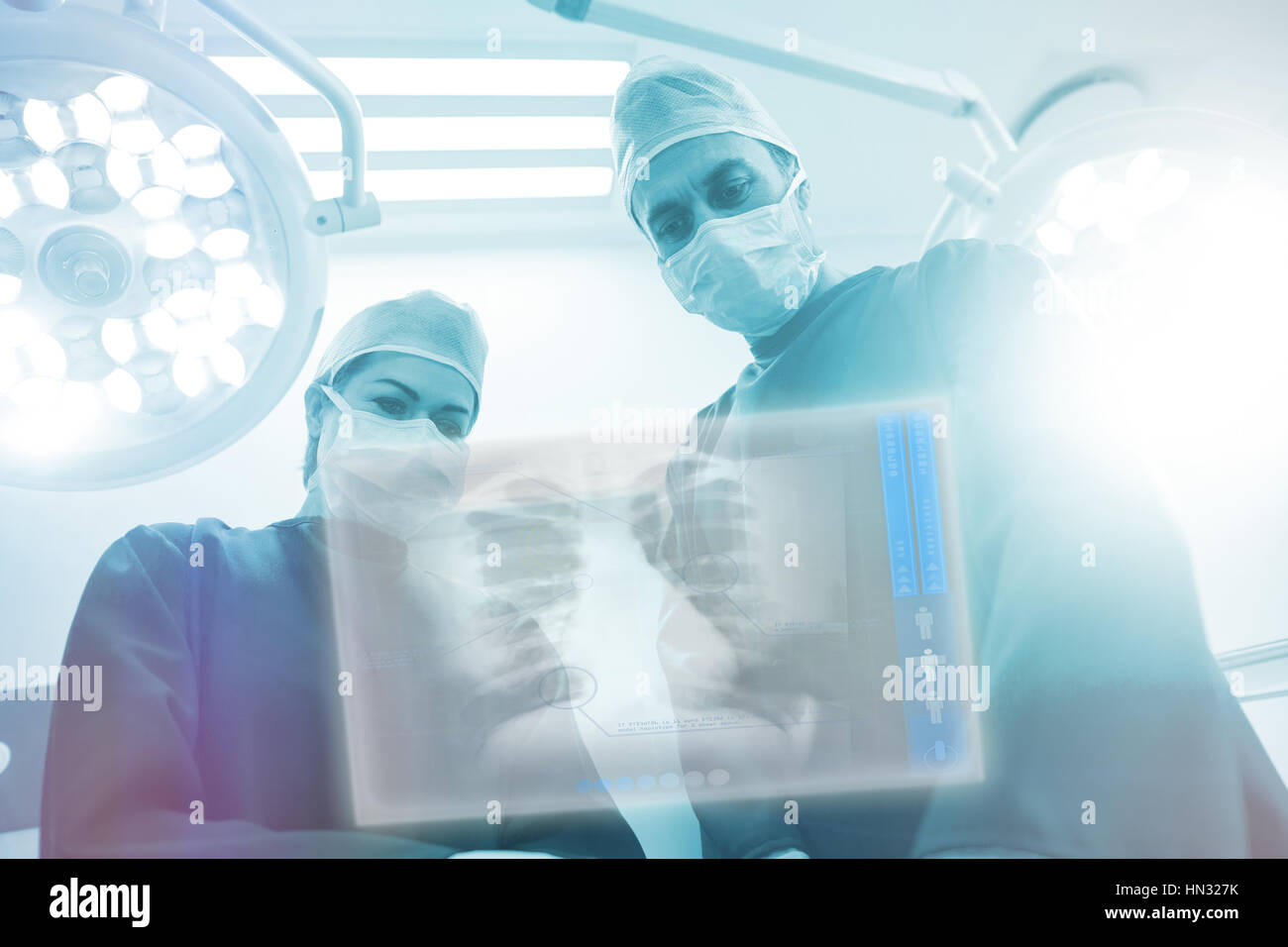 Xray of human chest on digital surface against surgeons performing ...