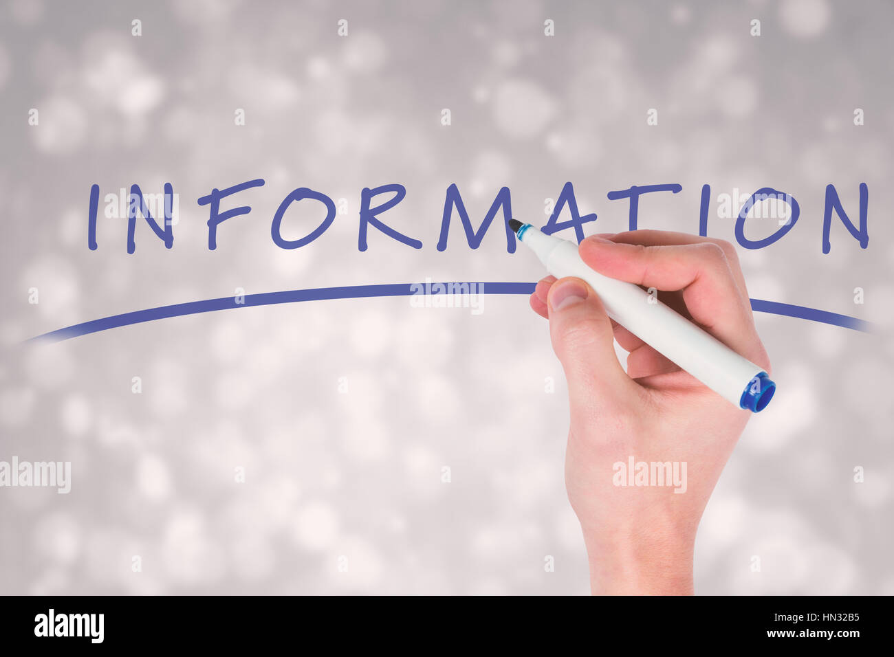 Hand writing with a marker against grey abstract light spot design ...