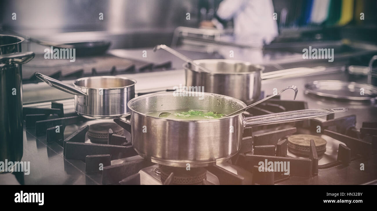 Chrome pot standing on hotplate in professional kitchen Stock Photo - Alamy