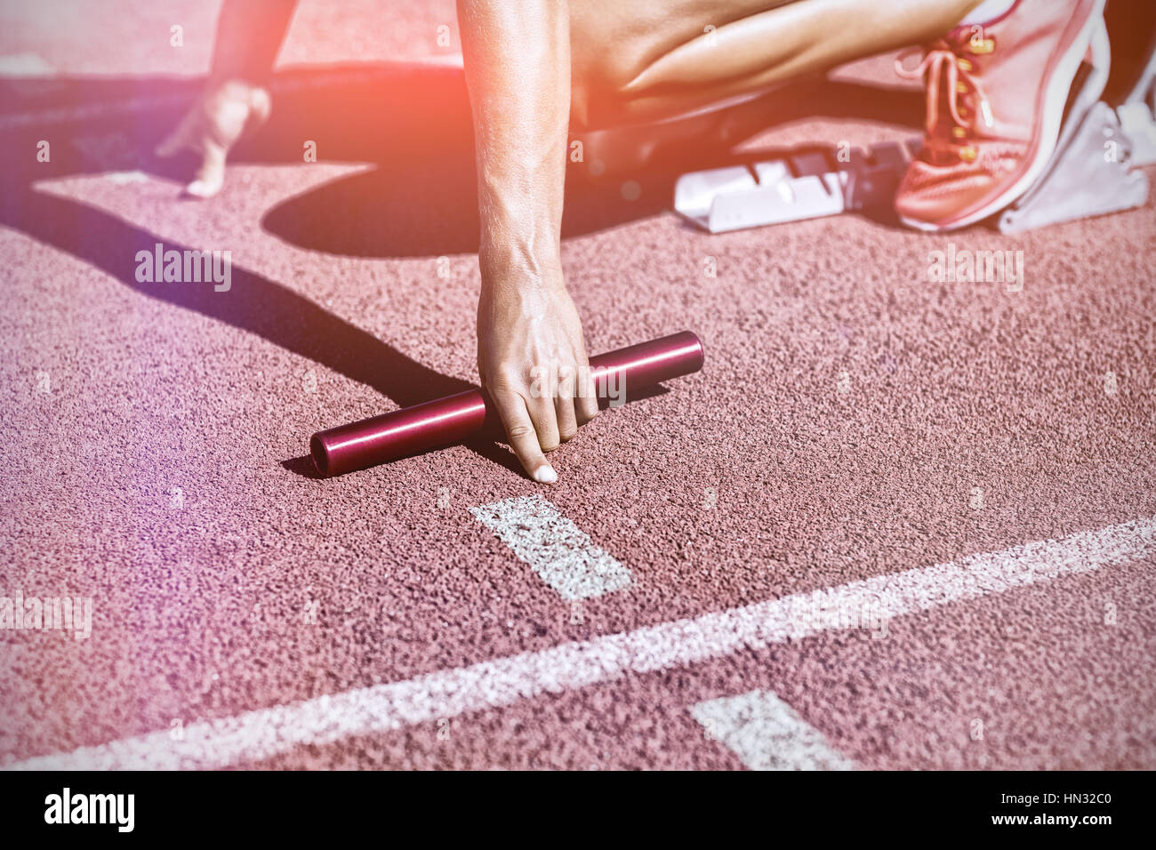 Female athlete ready to start relay race on running track Stock Photo ...