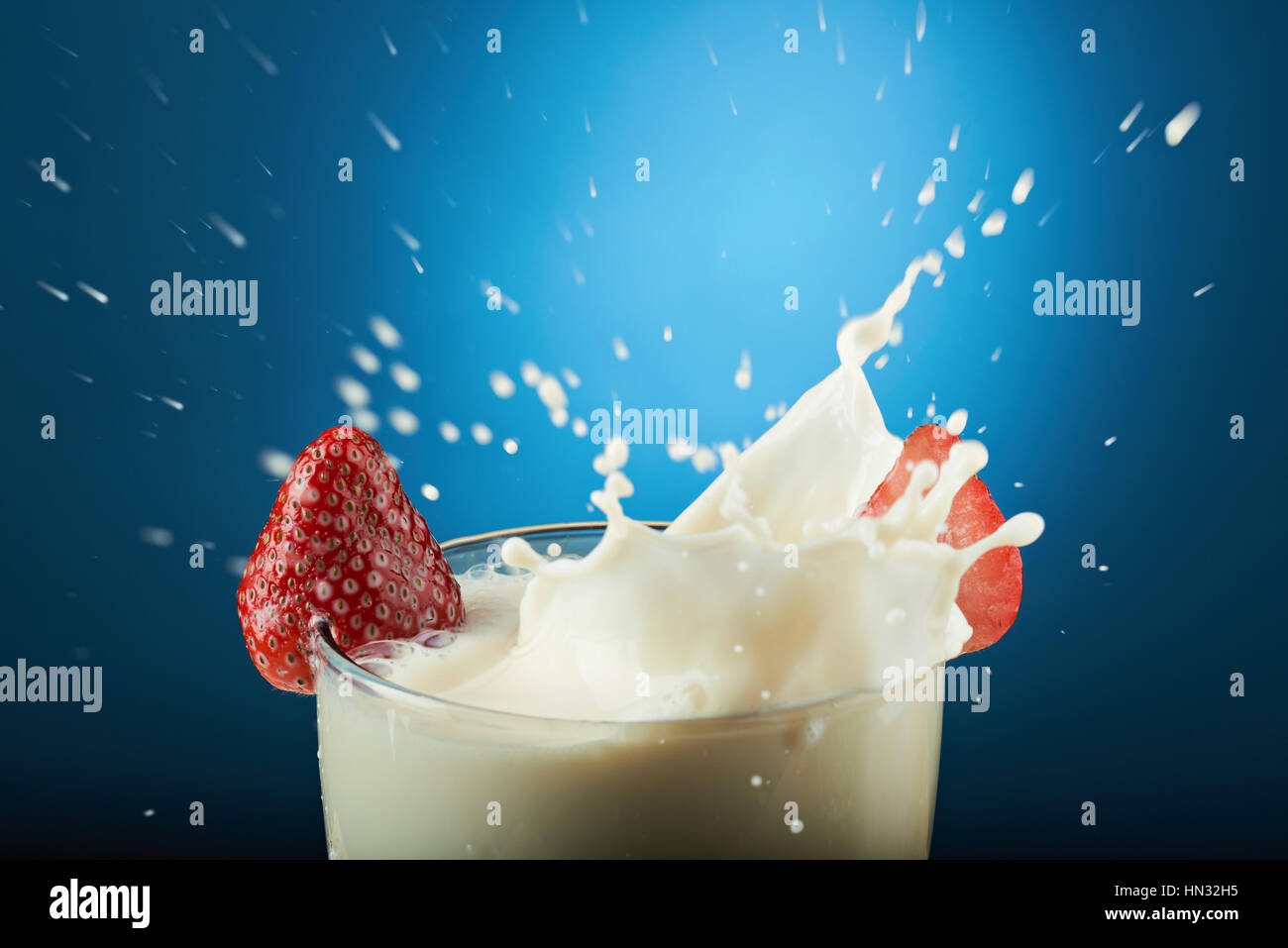 milk drop from splash isolated on blue background Stock Photo - Alamy