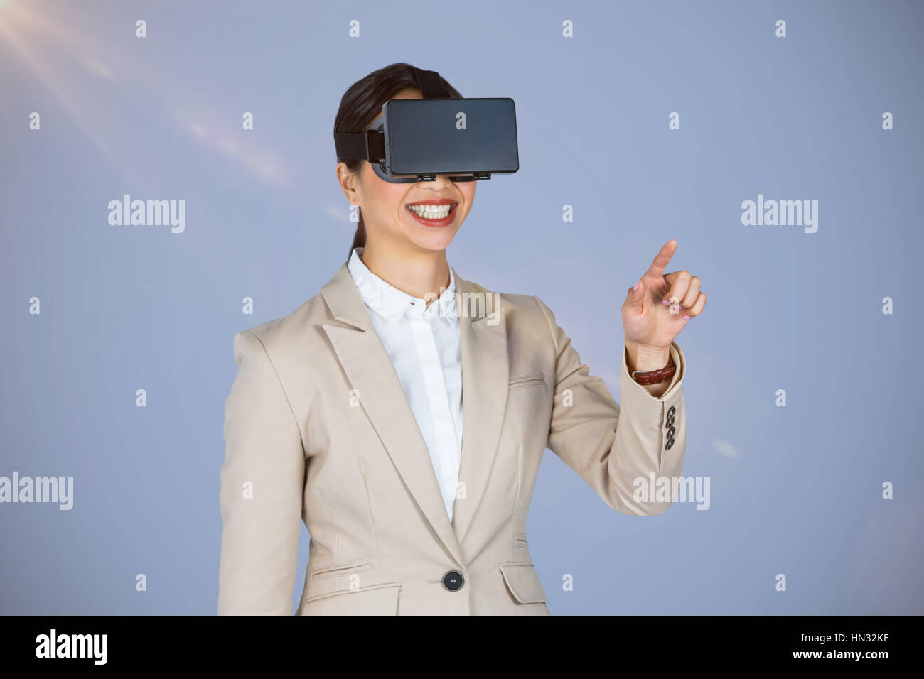 Smiling businesswoman pointing while wearing virtual video glasses ...
