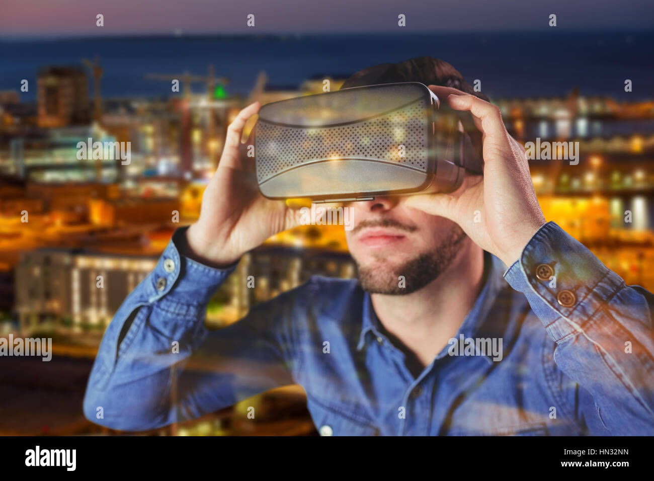 Man using an oculus against illuminated buildings in city Stock Photo ...
