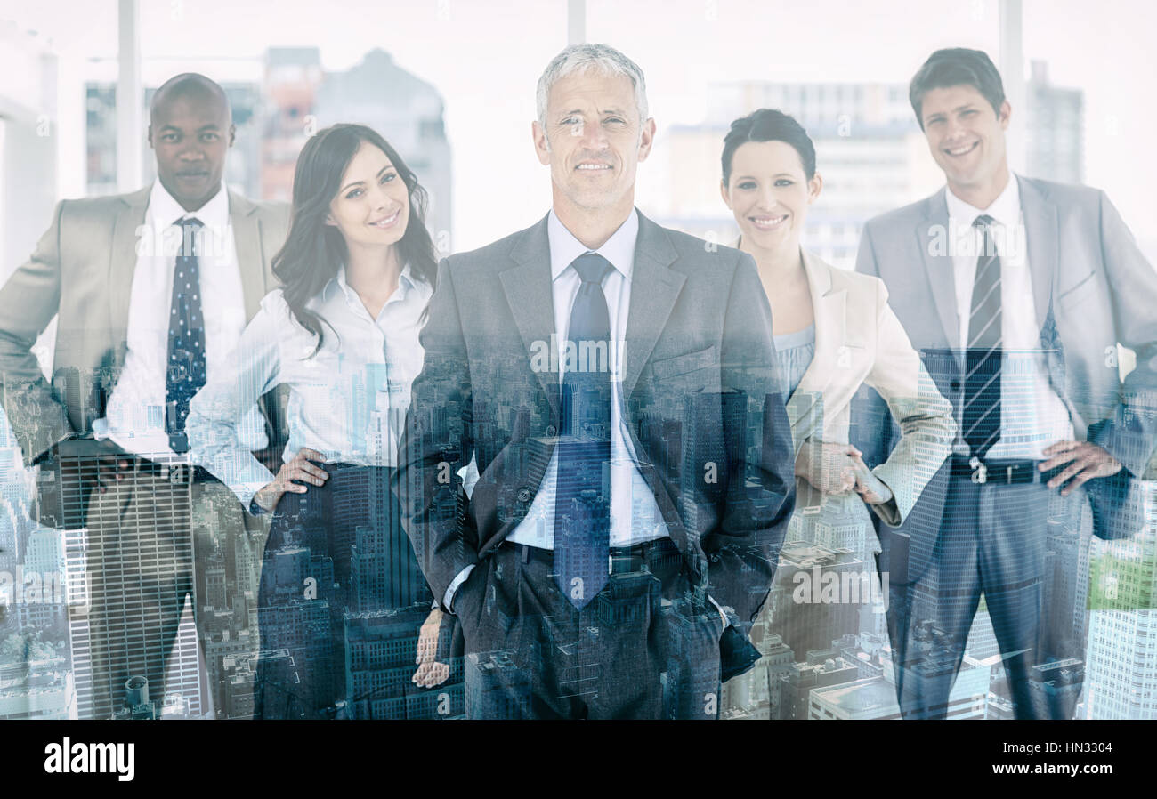 Smiling business team standing upright with their hands on their hips ...