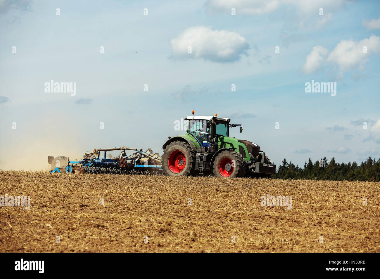 Green Tractor with cultivator handles field before planting Stock Photo ...