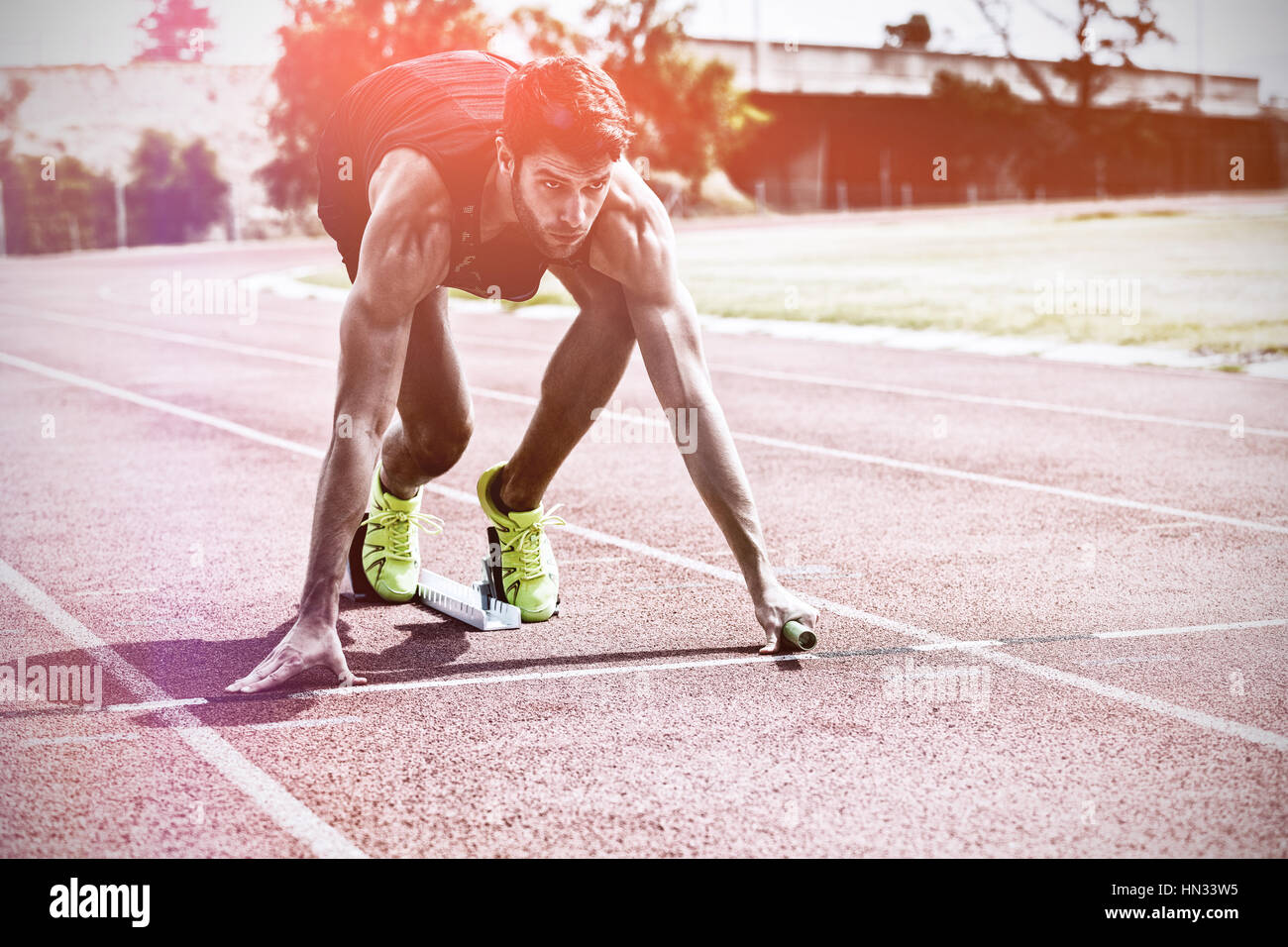 Athlete ready to start relay race on running track Stock Photo - Alamy