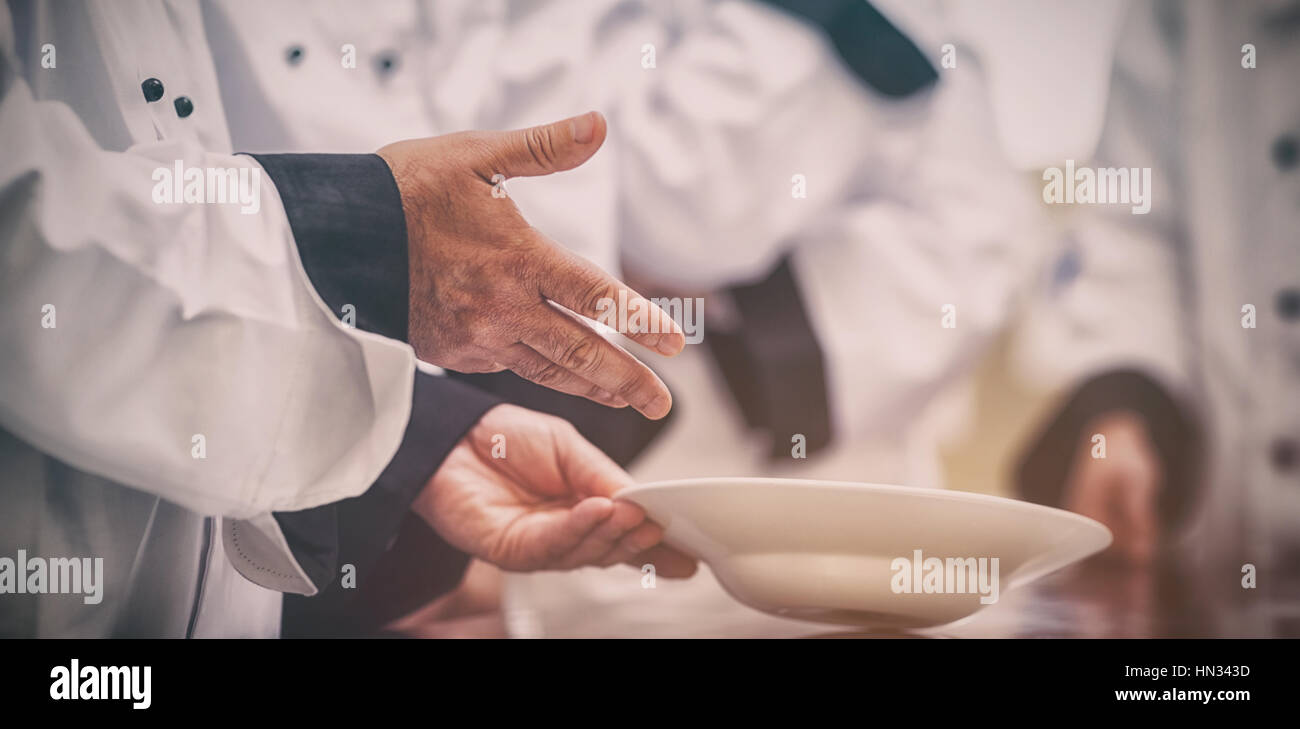 Chef showing class bowl in kitchen Stock Photo - Alamy