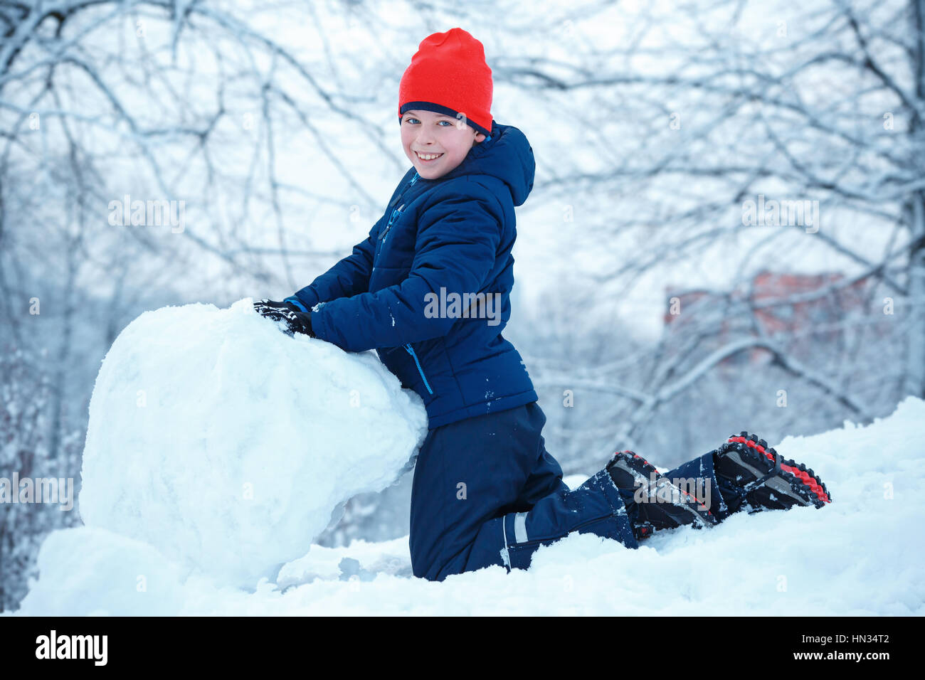 Little boy making a snowman Stock Photo - Alamy