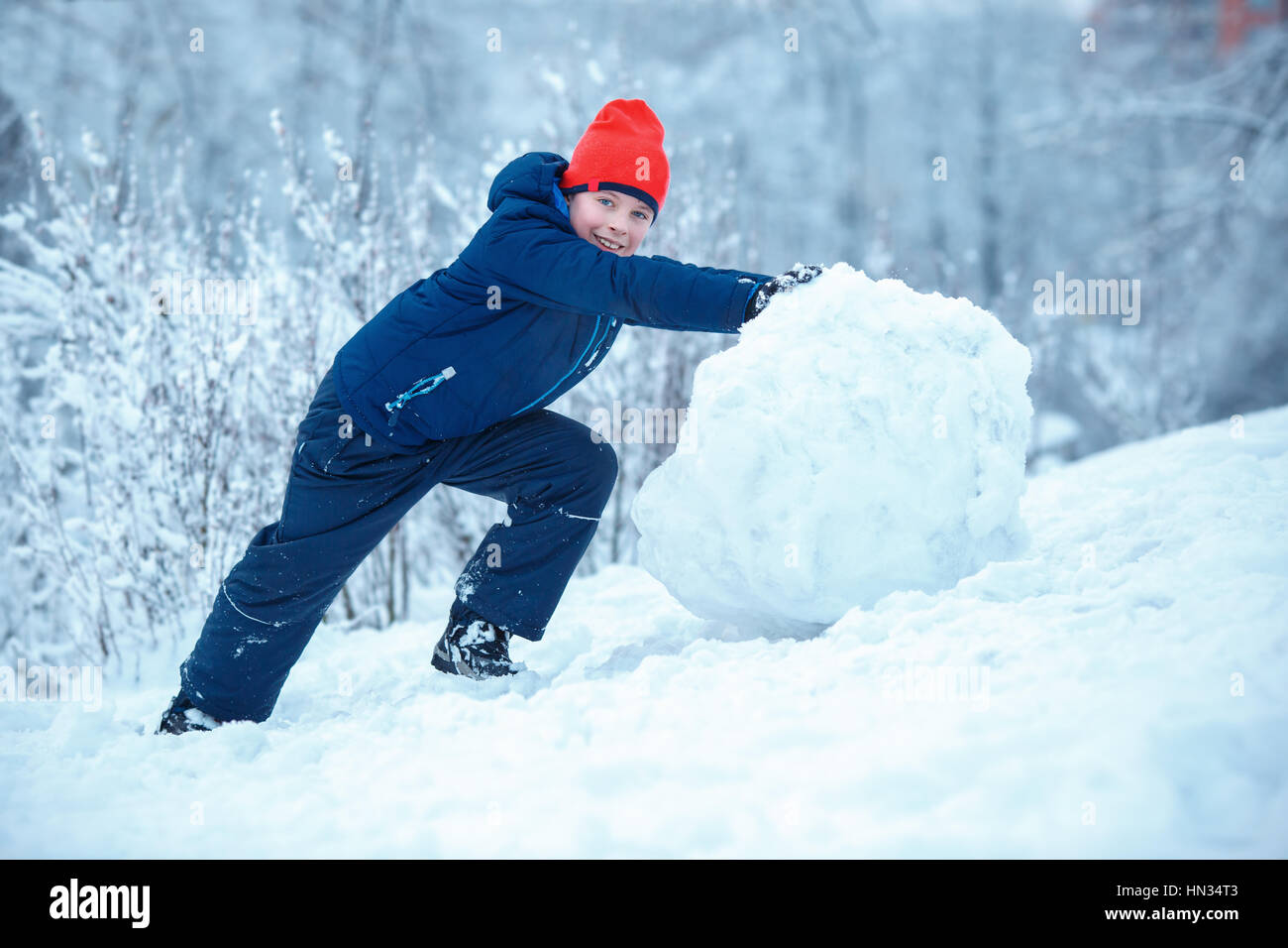 Little boy making a snowman Stock Photo - Alamy