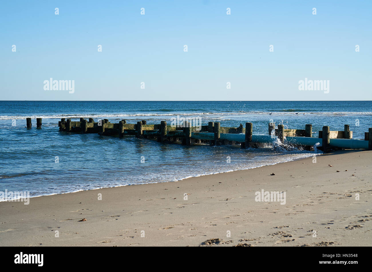 a wooden jetty covering a pipe that leads from the sea into the ...