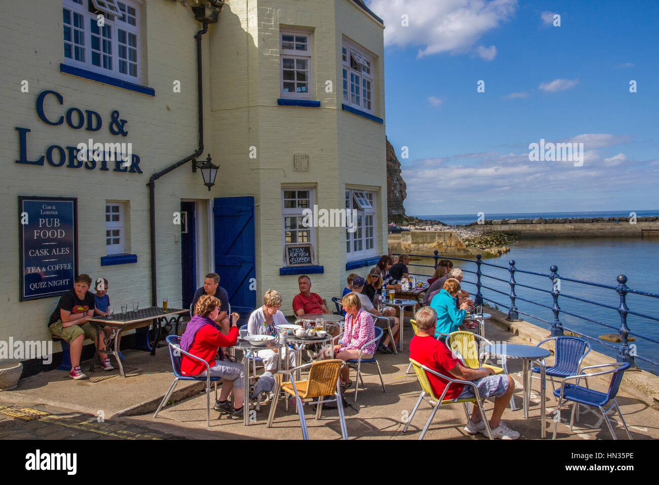 Enjoying a summer day outside a seaside pub Stock Photo - Alamy