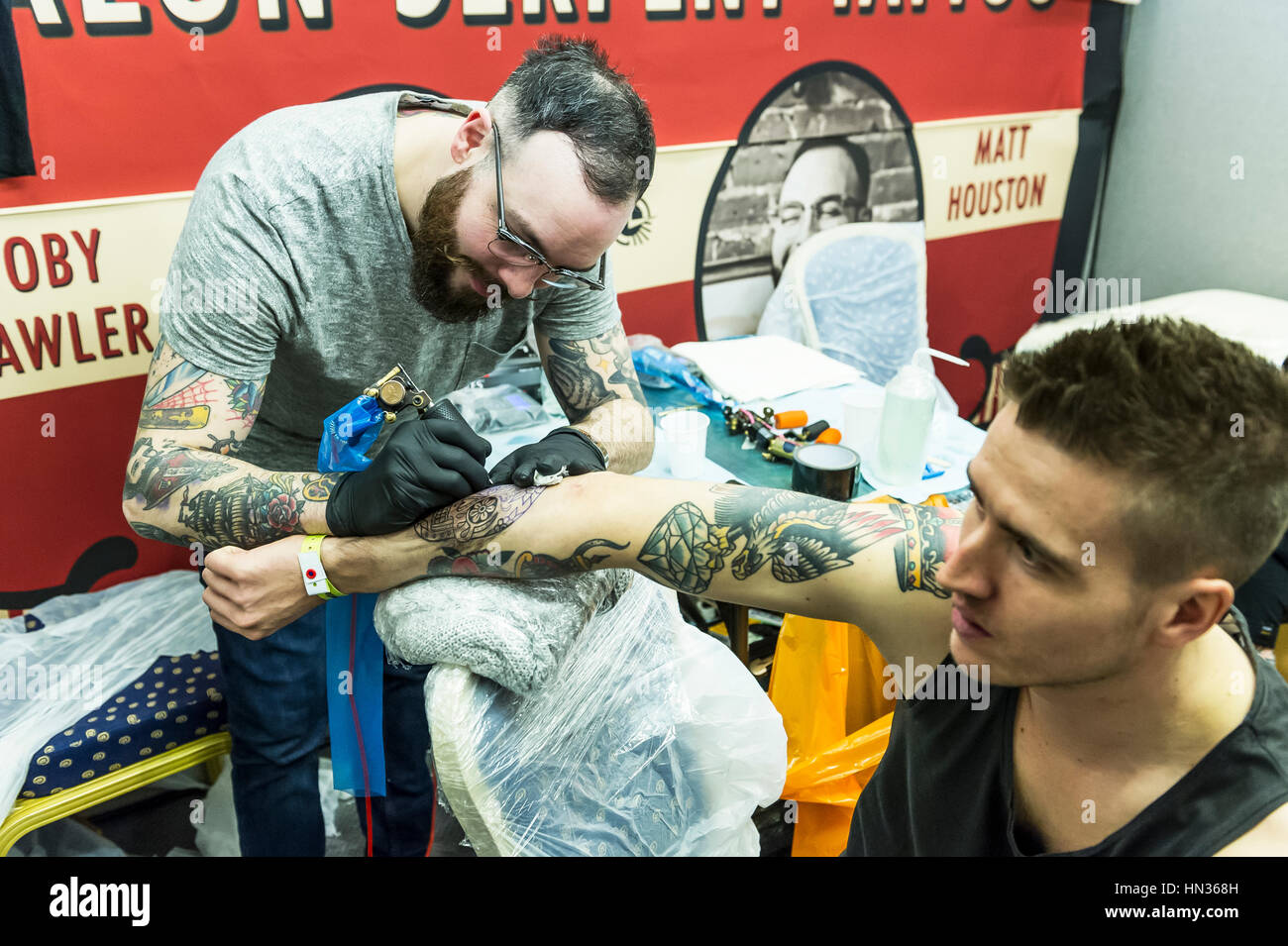 A man being tattooed on his arm Stock Photo - Alamy