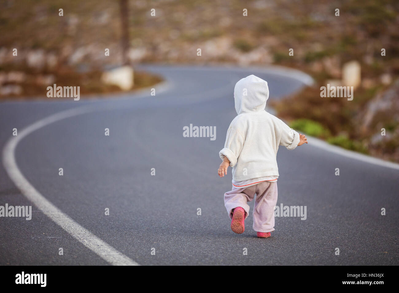 Little girl running down road in countryside, rear view Stock Photo - Alamy