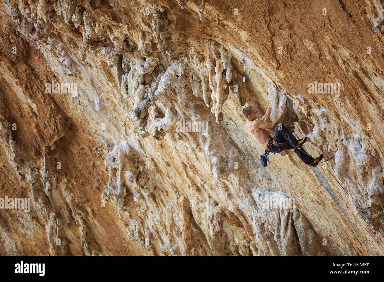 Tired rock climber resting before reaching next handhold. Challenging ...