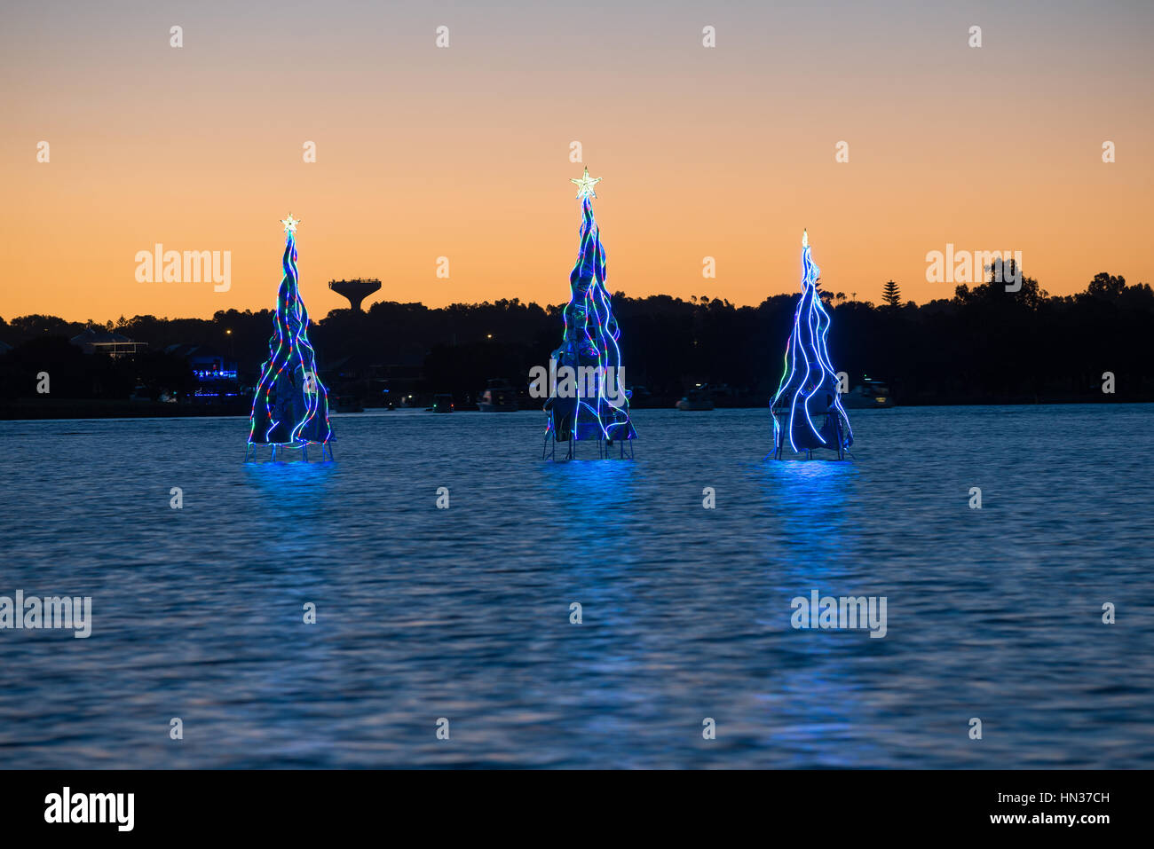 Christmas trees in the sea water with illumination at sunset Stock ...