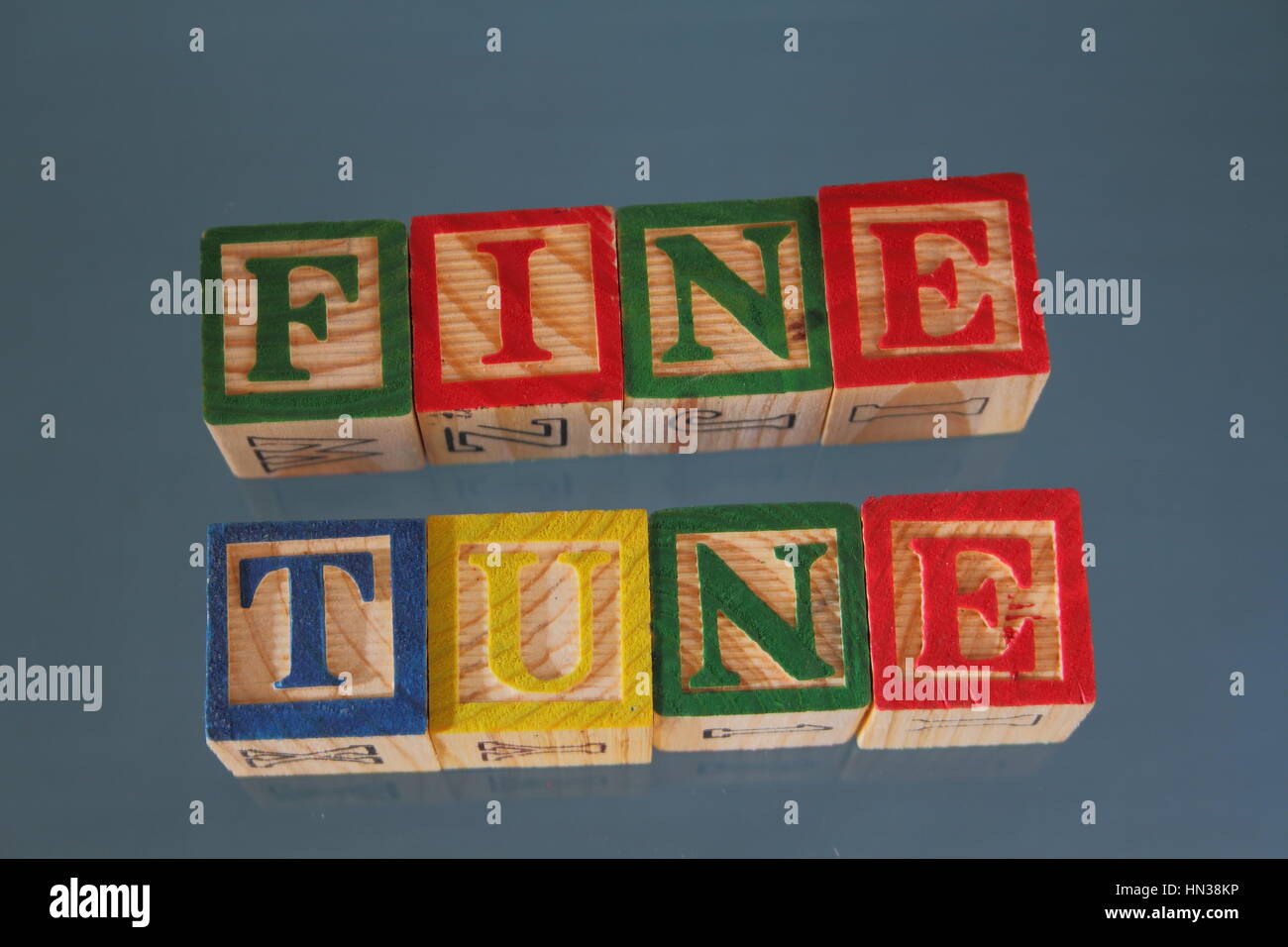 The term fine tune displayed on a clear blue background using colorful ...