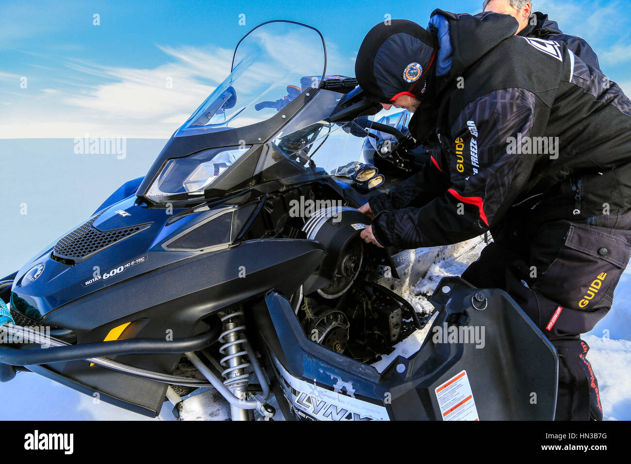 Man Performing Mechanical Repair On Snowmobile In Northeast Greenland ...