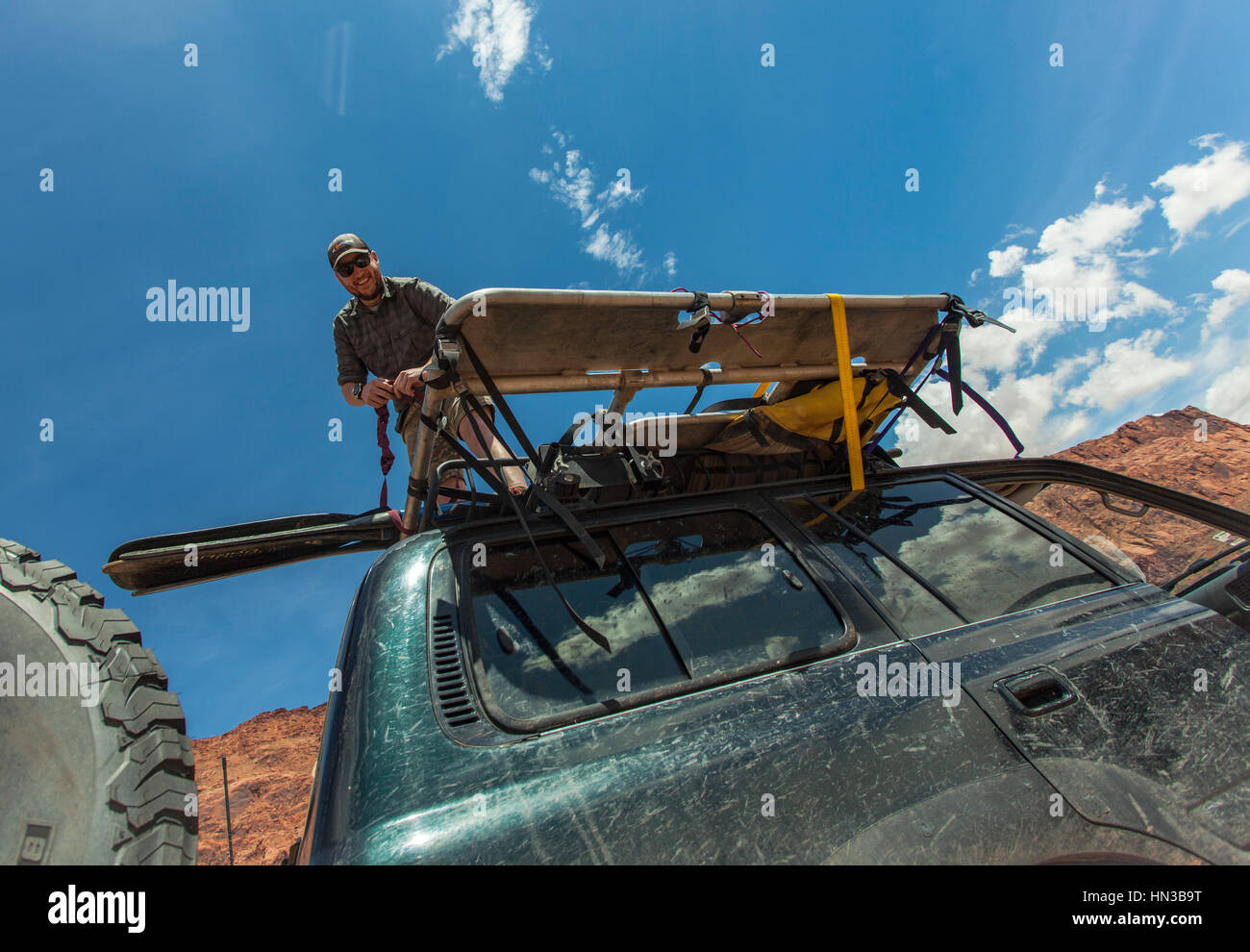 Low Angle View Of Man Unloading Gear From The Top Of Vehicle Stock ...