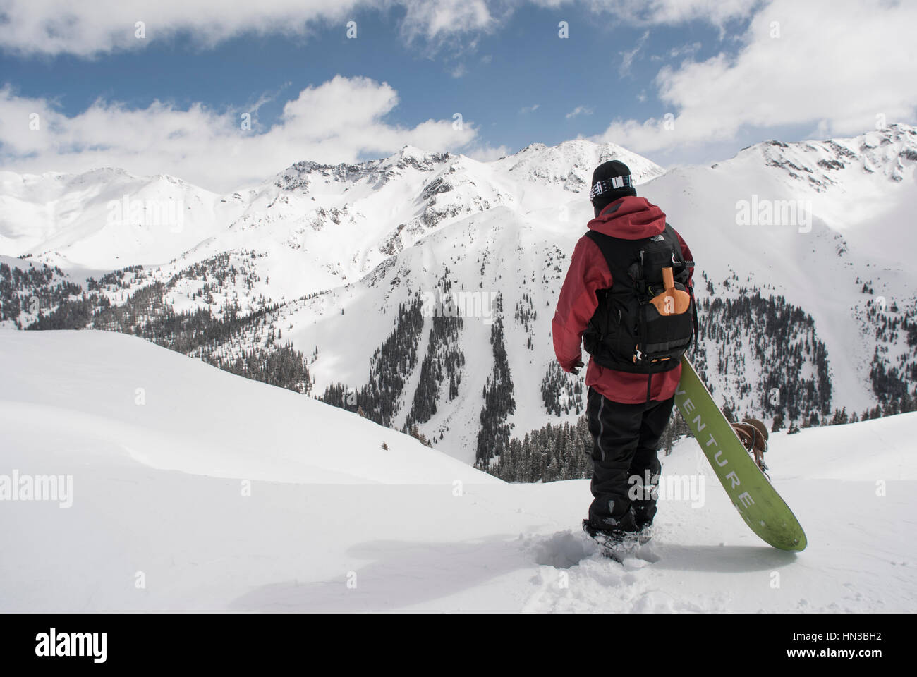 Man Standing With His Snowboard Looking Over Avalanche Paths At ...