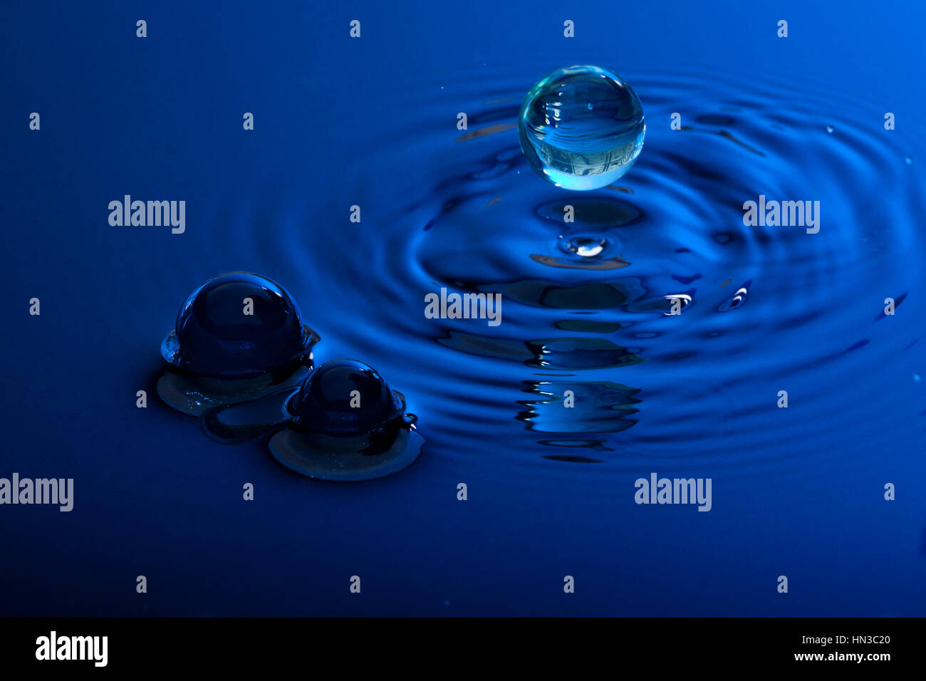 falling water drops splashing in water in blue light Stock Photo - Alamy