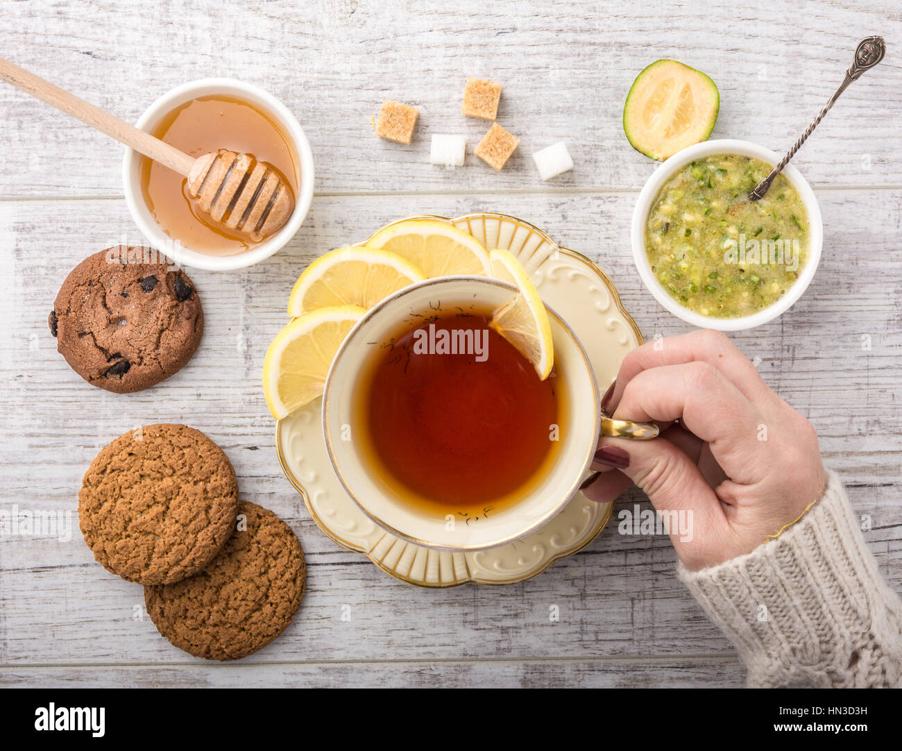 woman drinking tea with lemon . cookies, sugar , honey, feijoa and jam ...