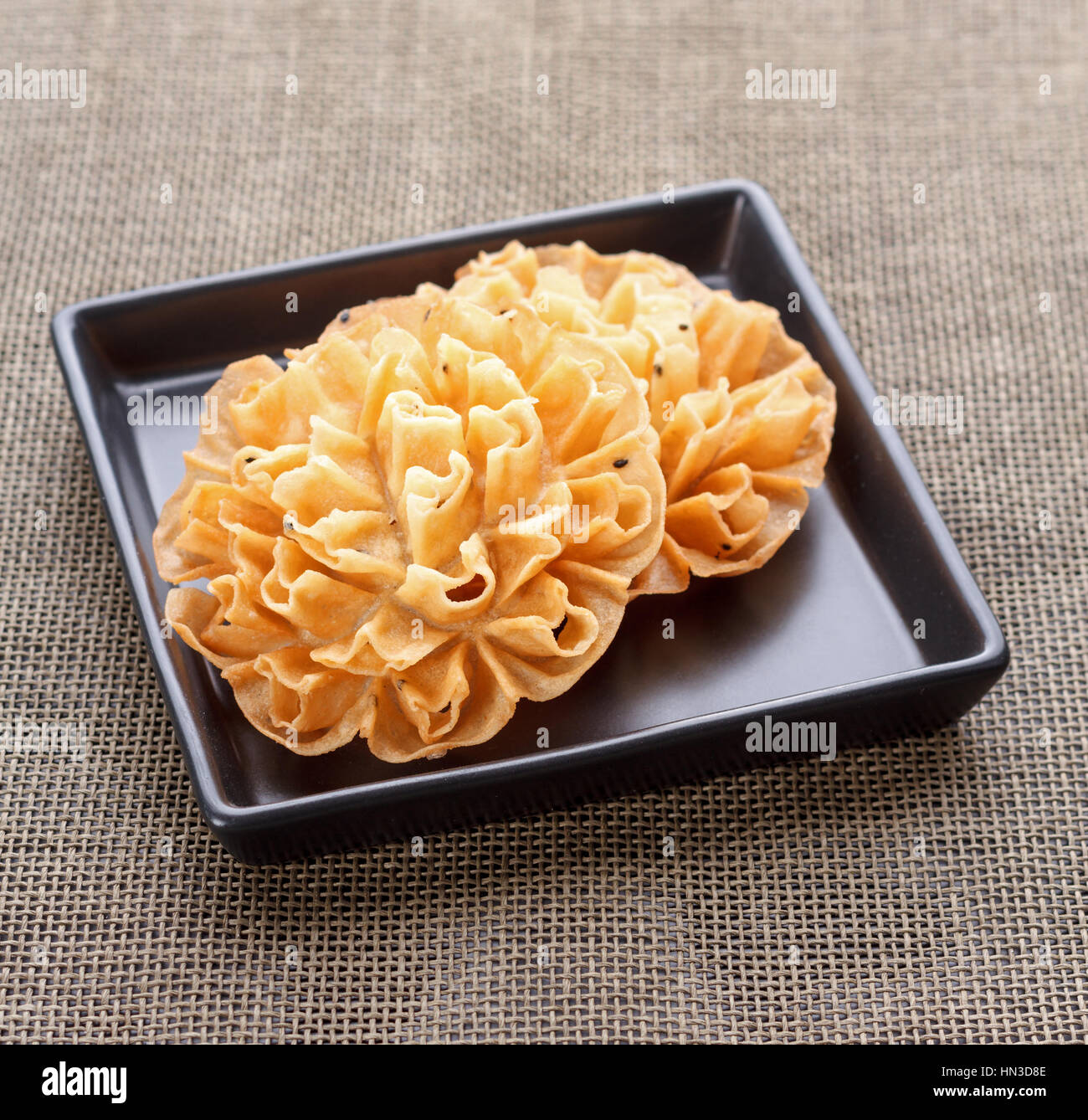Crispy Lotus Blossom Cookie on black dish ("Dok Jog" in Thai made from ...