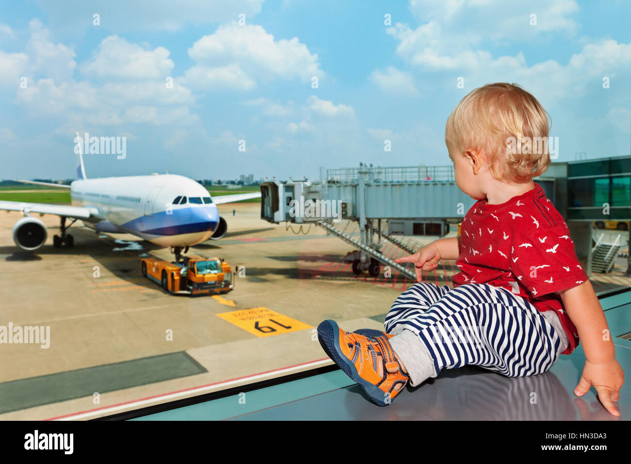 Little baby boy waiting boarding to flight in airport transit hall and ...