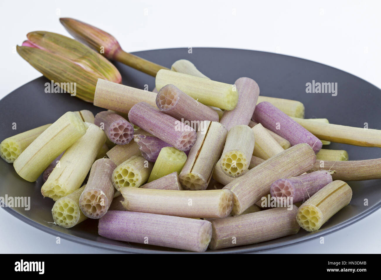 Cut Lotus stem ready for cooking on black dish Stock Photo - Alamy