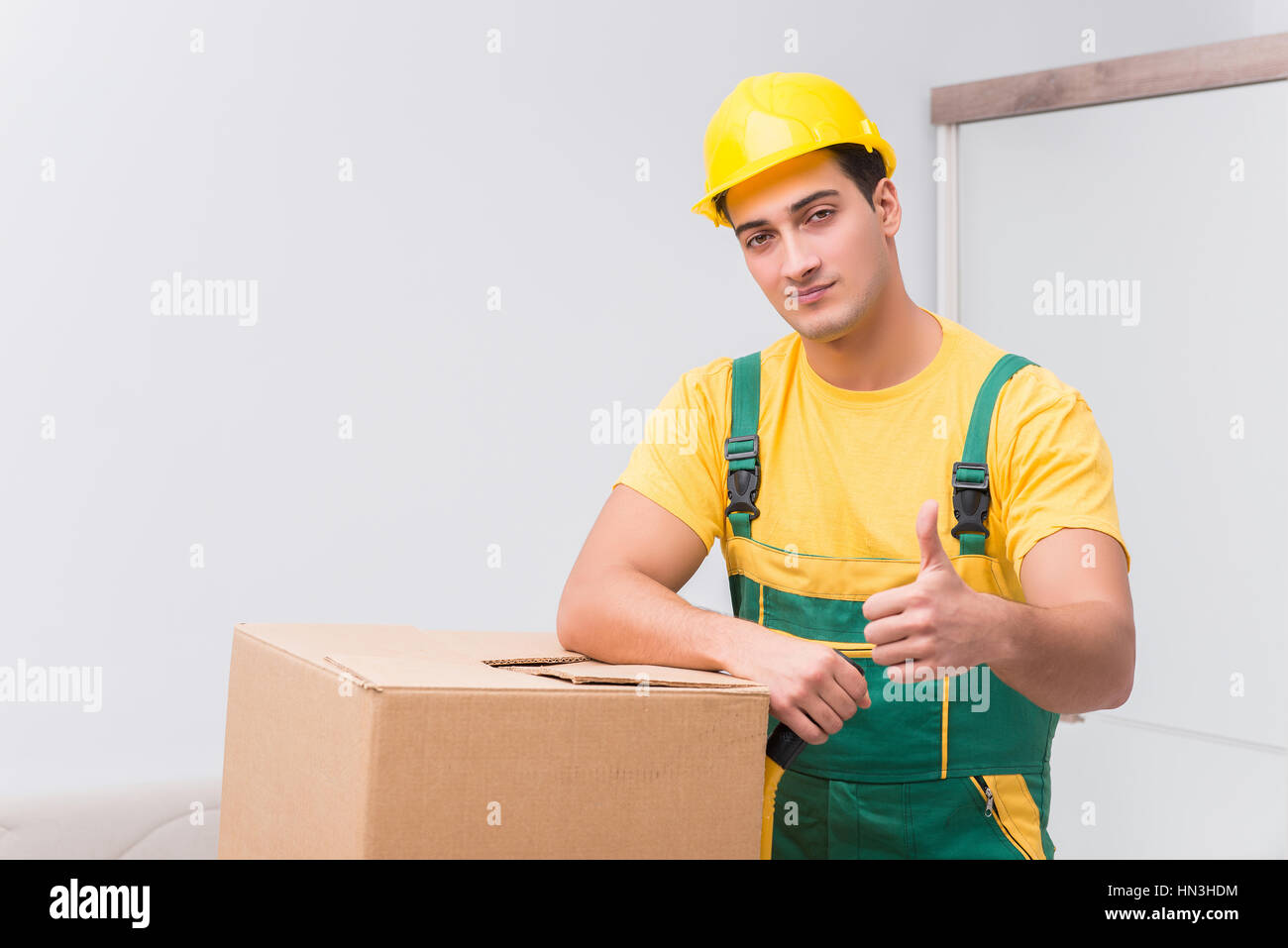 Transportation worker delivering boxes to house Stock Photo - Alamy