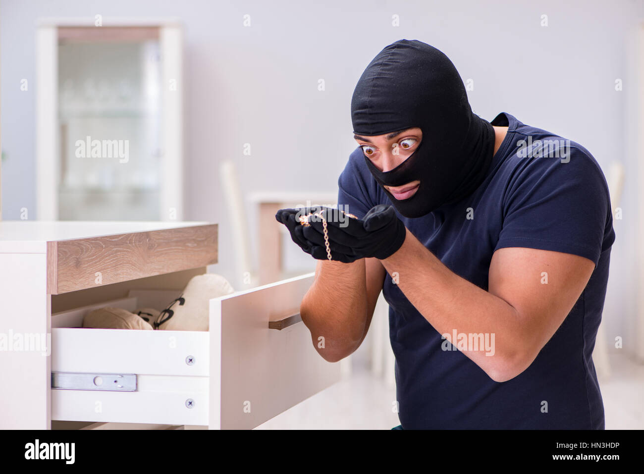 Robber wearing balaclava stealing valuable things Stock Photo - Alamy