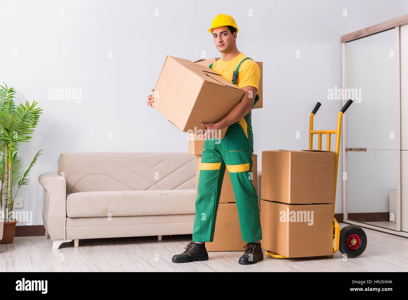 Transportation worker delivering boxes to house Stock Photo - Alamy