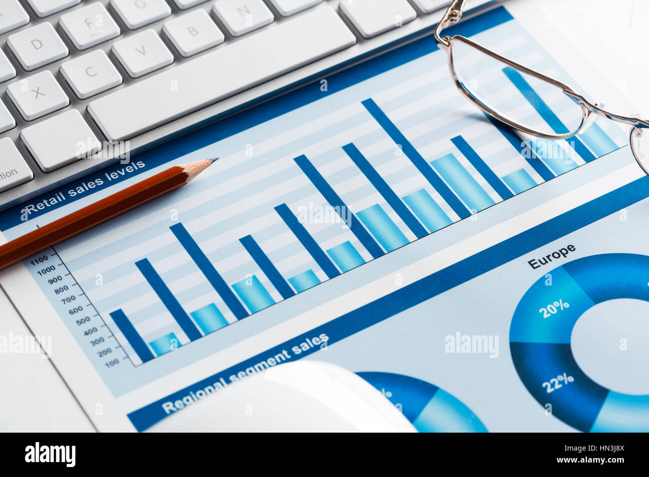 Business workplace with keyboard mouse and papers with graphs and ...