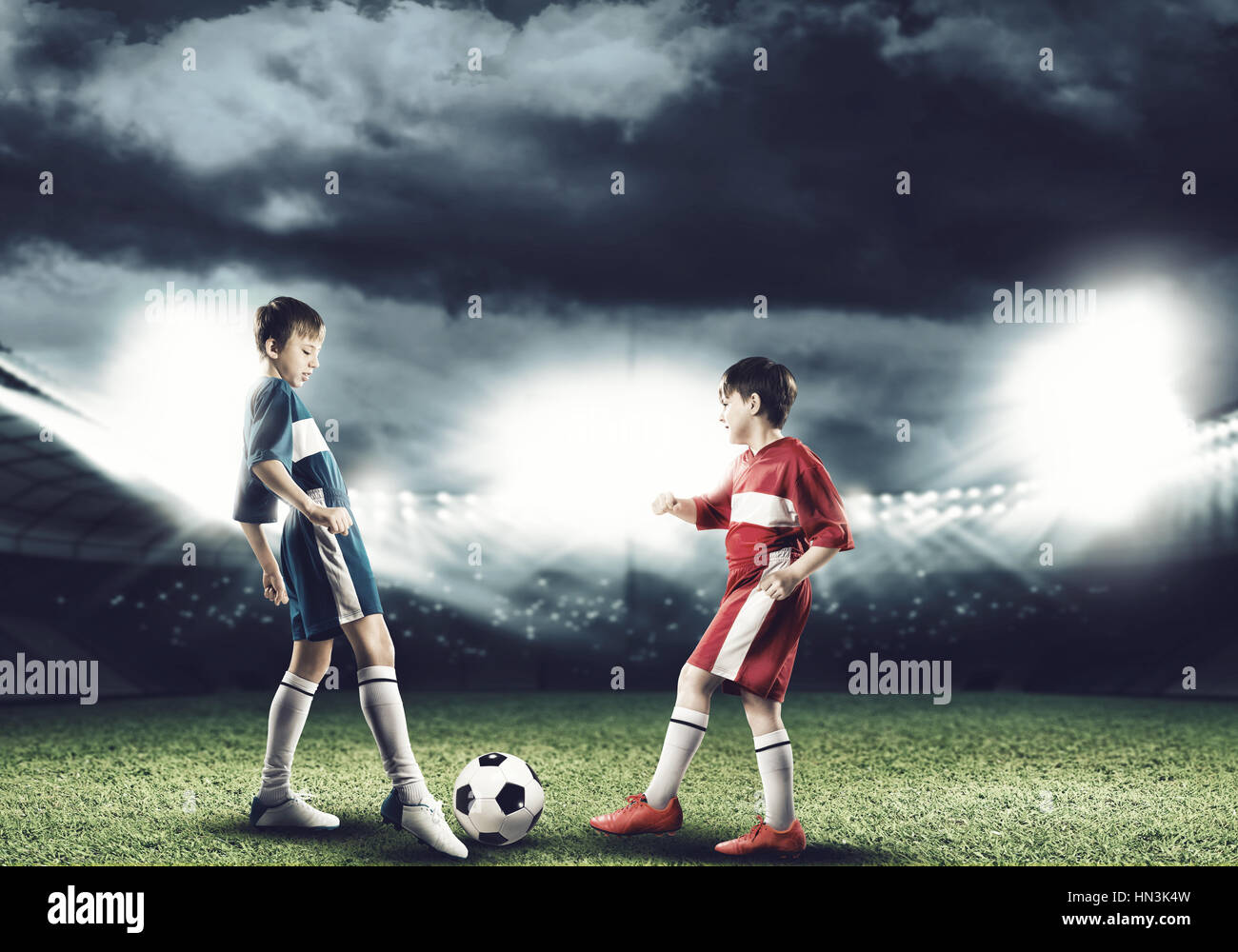 Two boys of school age playing football on stadium Stock Photo - Alamy