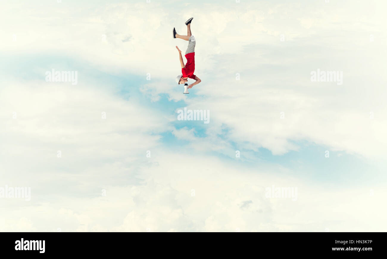 Young cheerful man with megaphone flying high in sky Stock Photo - Alamy