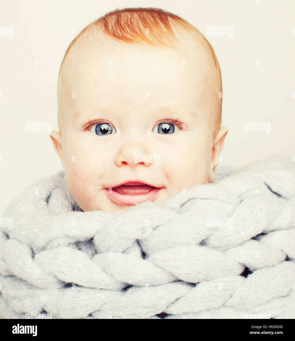 little cute red head baby in scarf all over him close up isolate Stock ...
