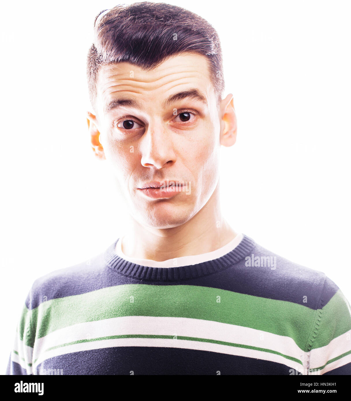 Portrait of a smart serious young man standing against white bac Stock ...