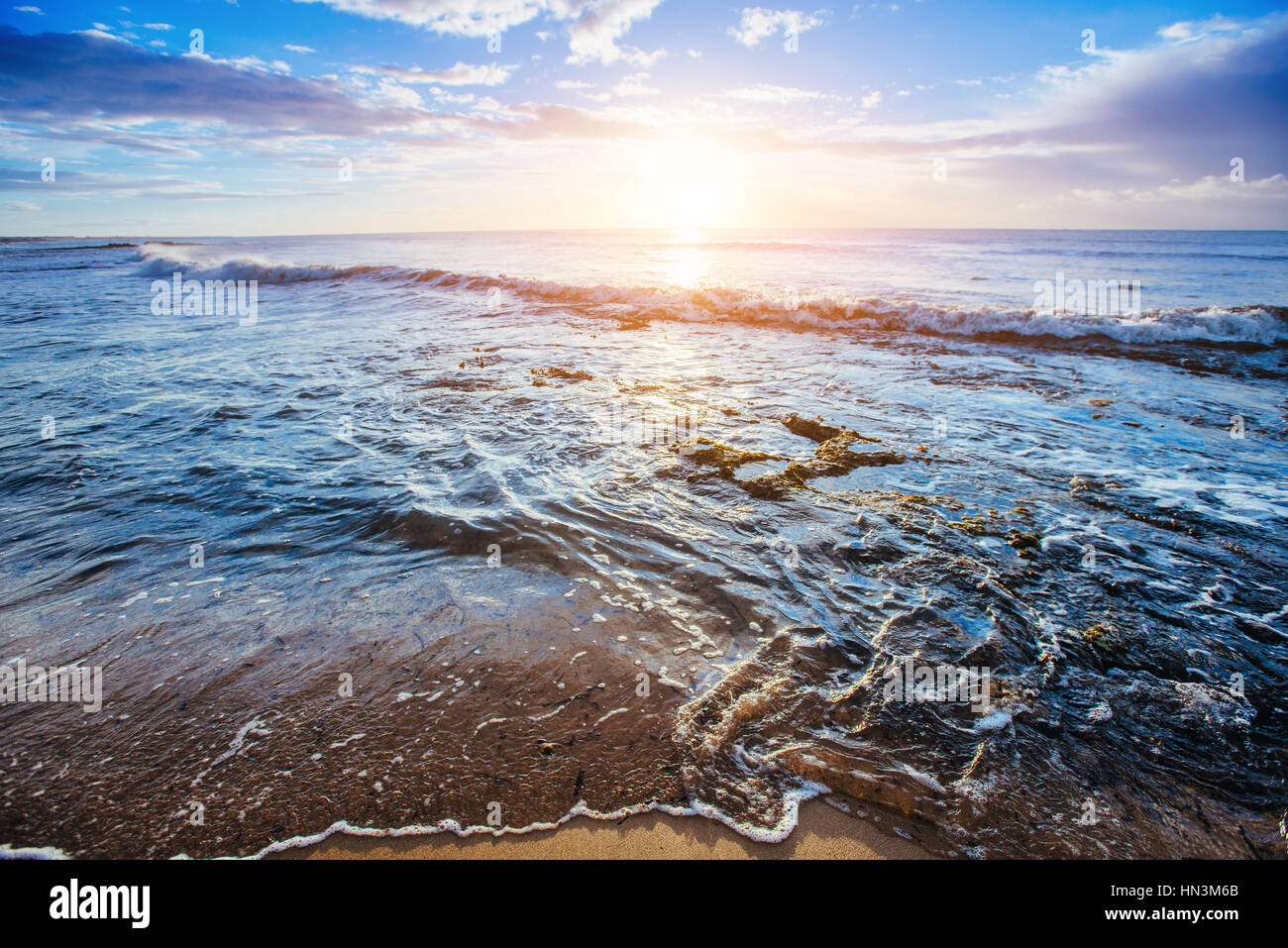 Sunset on the sandy beach Stock Photo - Alamy