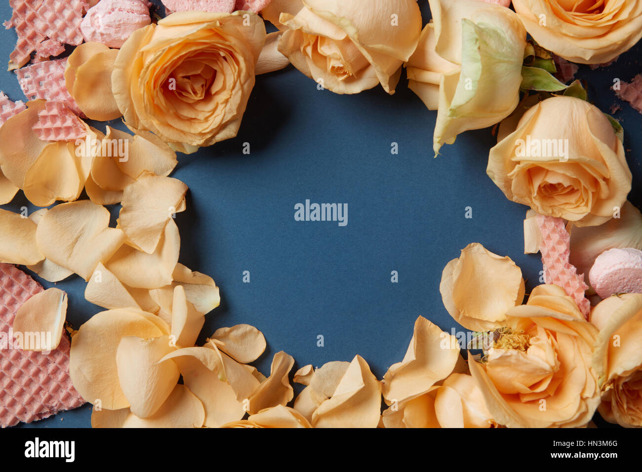 Frame made of waffles and roses as decoration on navy blue background ...