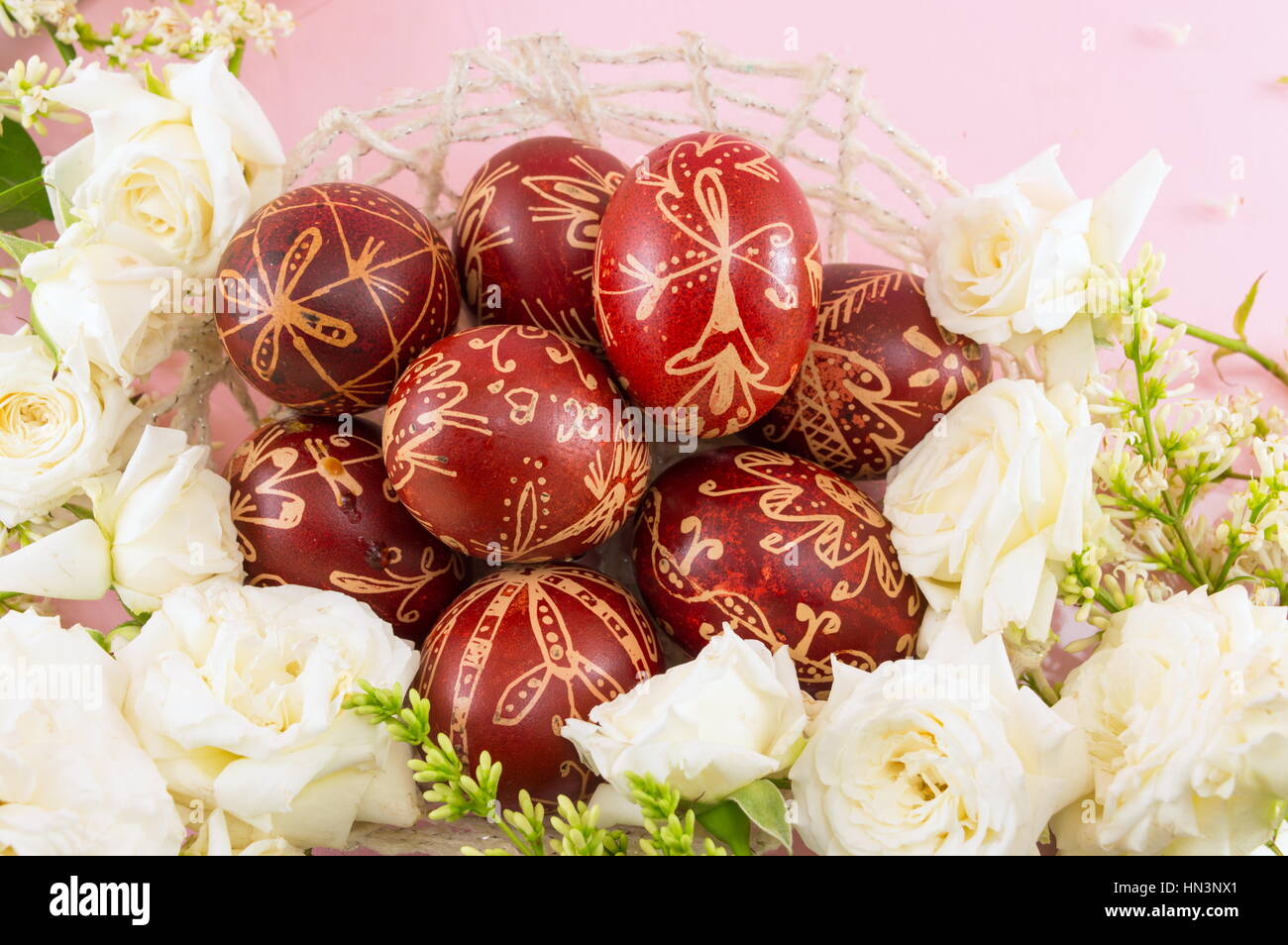 Wax decorated Easter eggs and white roses Stock Photo - Alamy