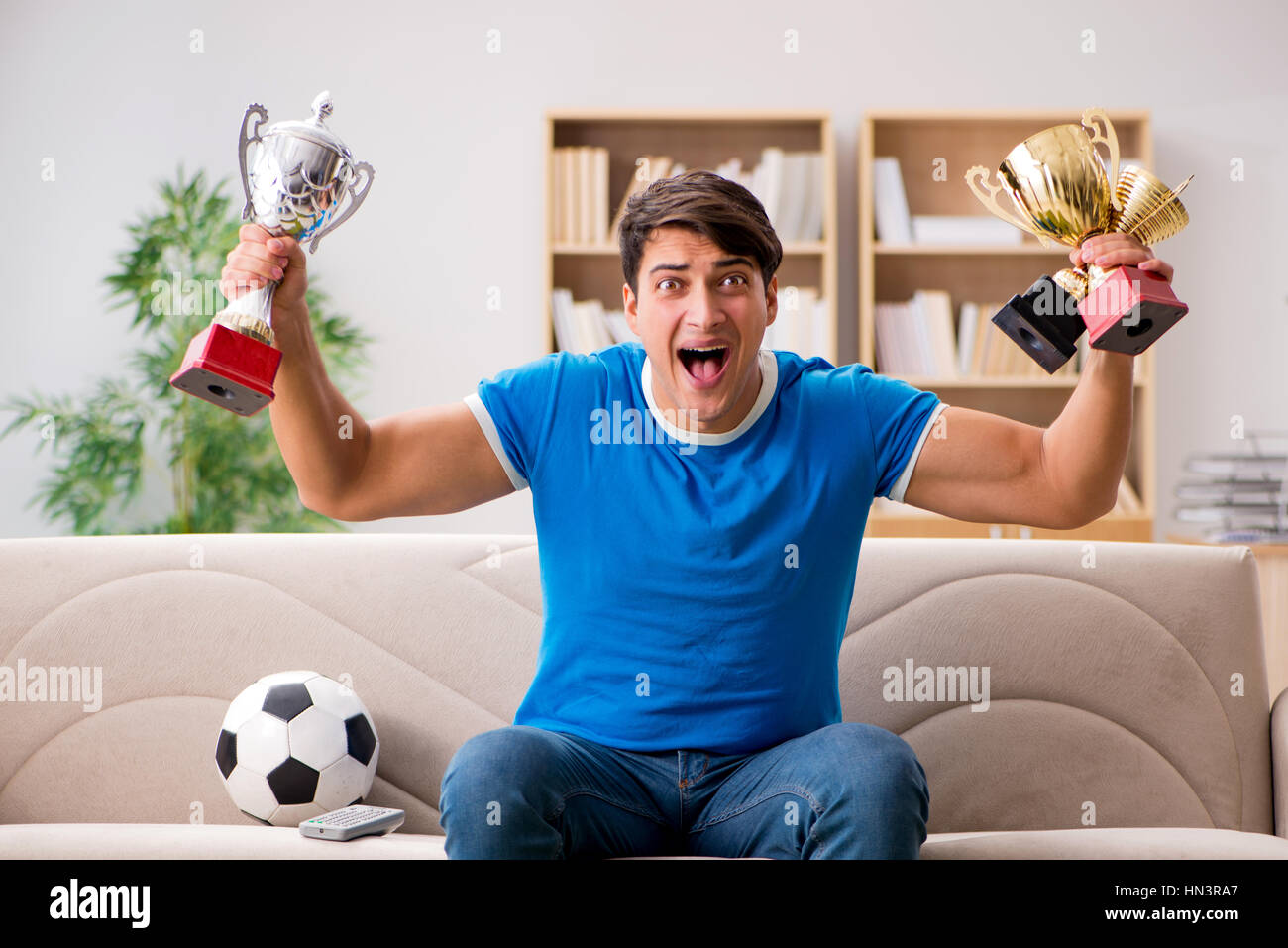 Man watching football at home sitting in couch Stock Photo - Alamy