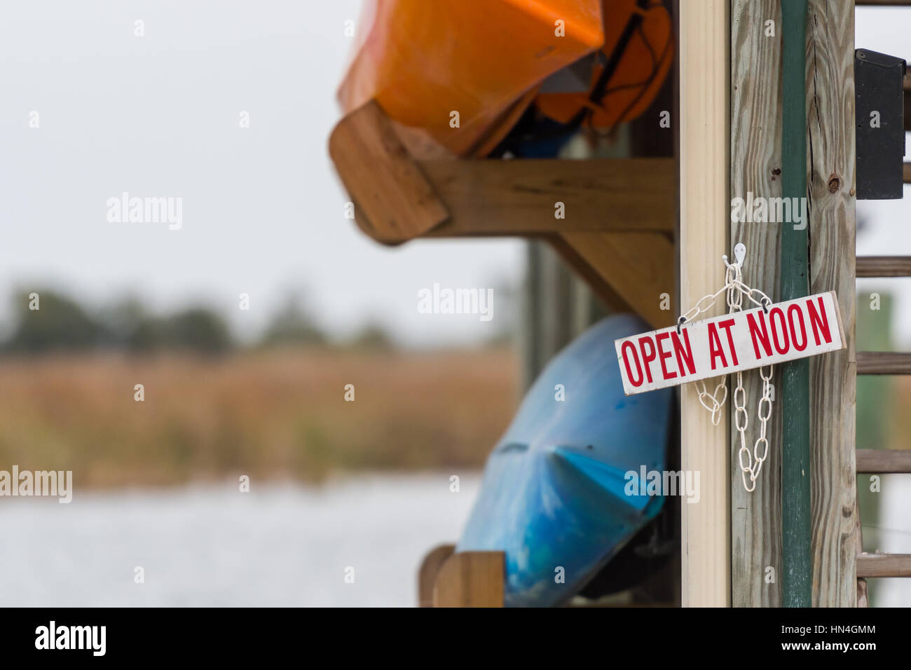 Open at Noon Sign with Two Kayaks hanging on ramp Stock Photo - Alamy