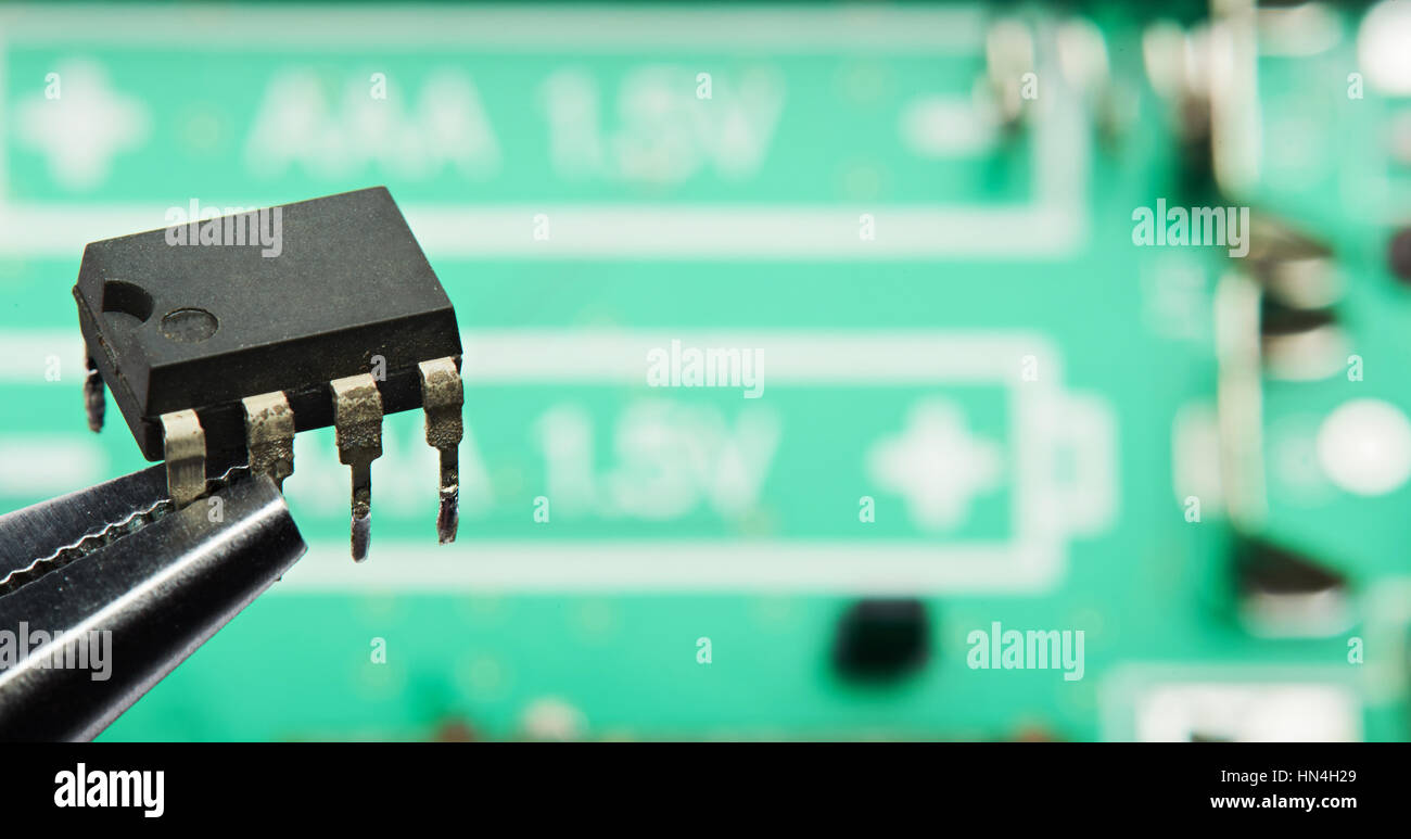 holding small resistor on green circuit background Stock Photo - Alamy
