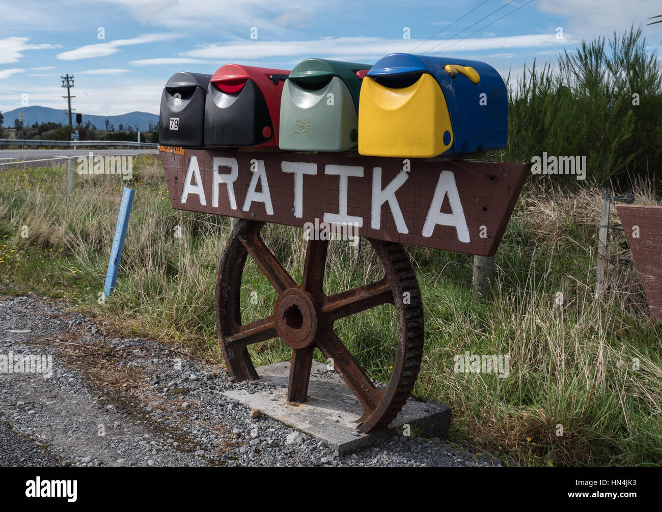 Mail boxes mounted on wheel and frame on the roadside. New Zealand ...