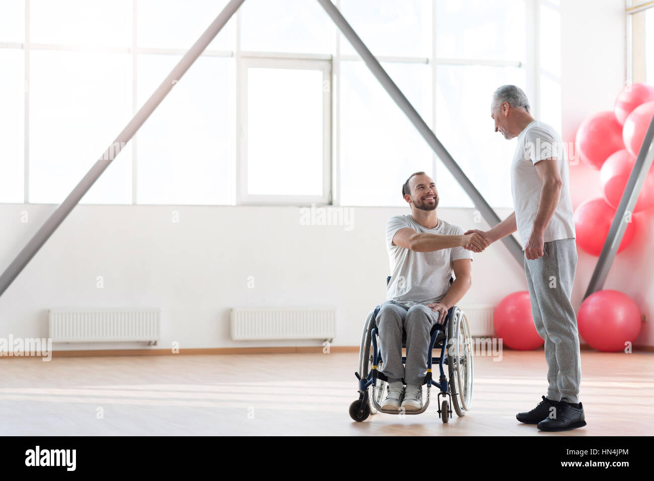 Positive physical therapist meeting with disabled patient in the gym ...