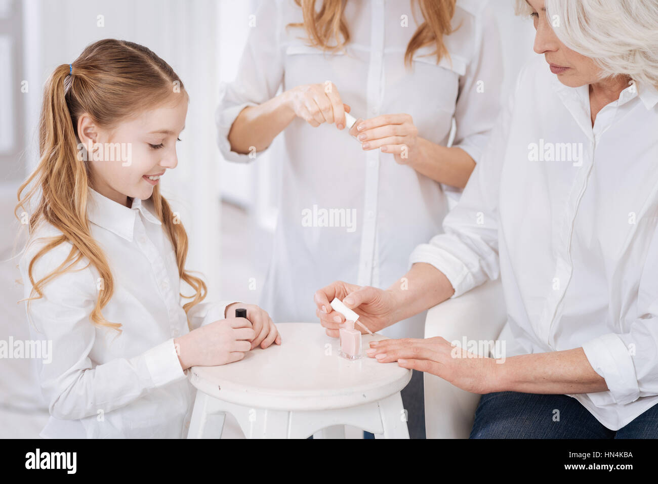 Cheerful female members of the family using nail polish Stock Photo - Alamy