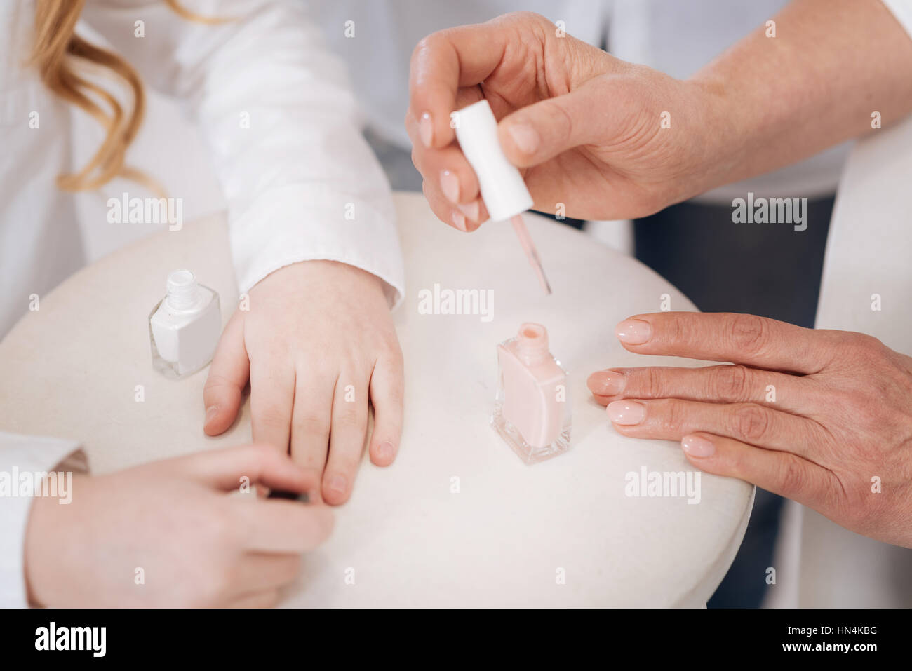 Pretty girl and grandmother using nail polish Stock Photo - Alamy