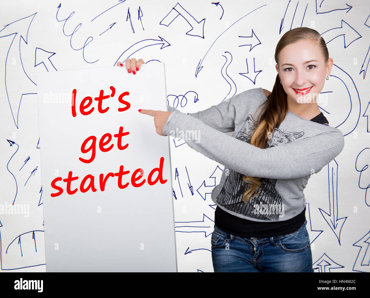 Young woman holding whiteboard with writing word: let's get started ...