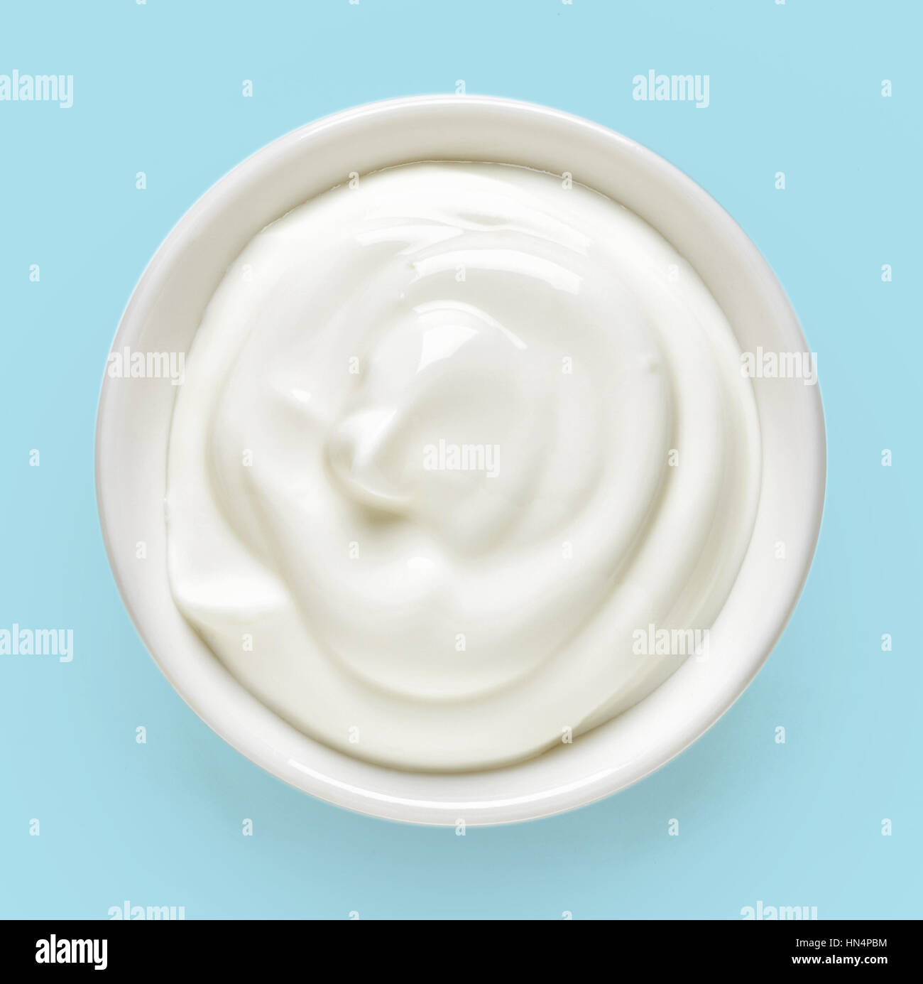 White bowl of cream on light blue background, top view Stock Photo - Alamy
