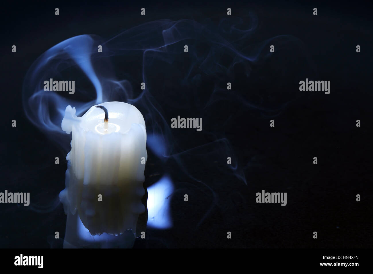Extinguished candle with smoke on dark background Stock Photo - Alamy