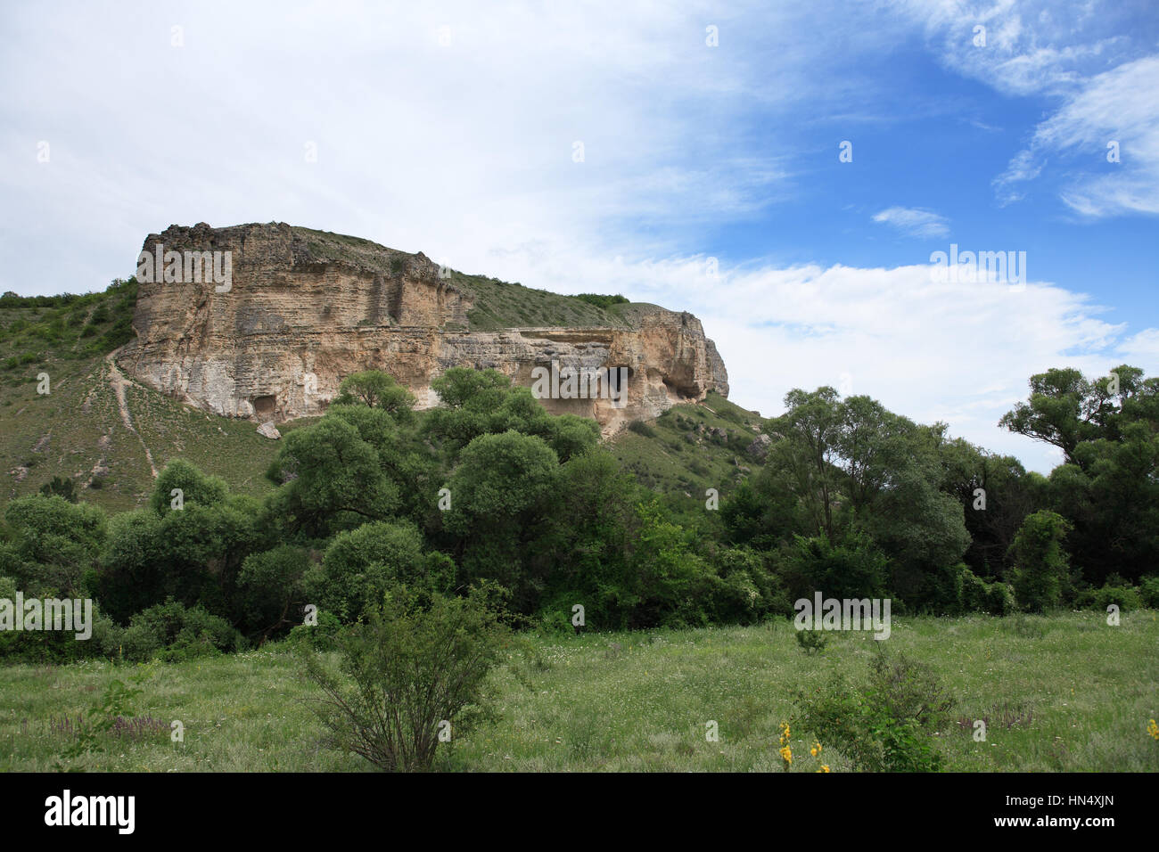 Old mountain with caves on background with blue sky and clouds Stock ...